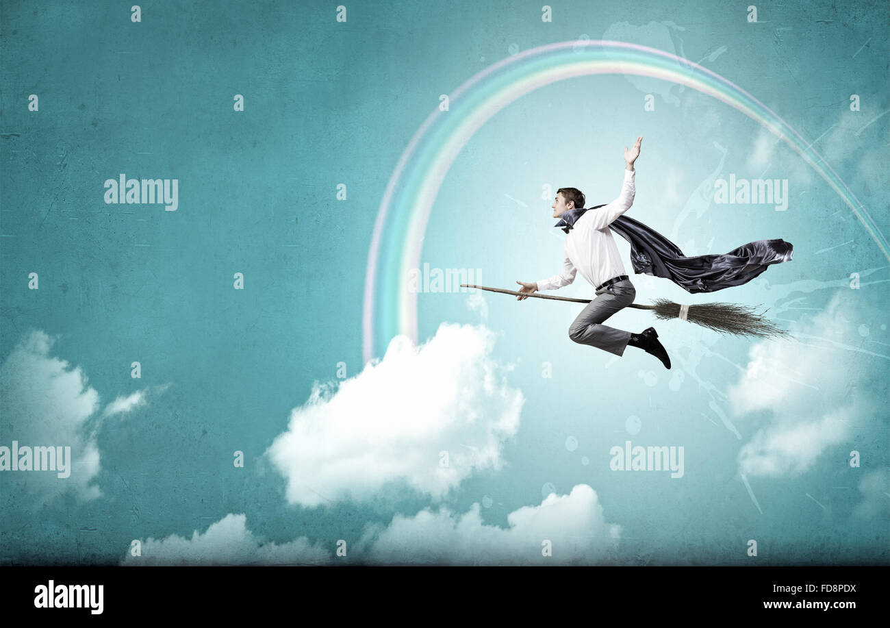 Young businessman flying on broom high in sky Stock Photo - Alamy