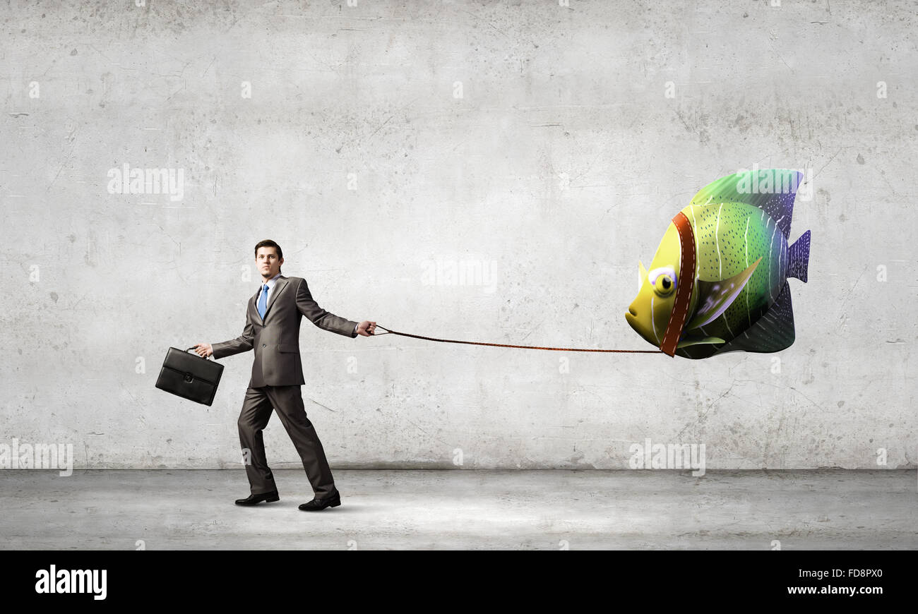 Young businessman and big exotic fish. Success in business Stock Photo ...