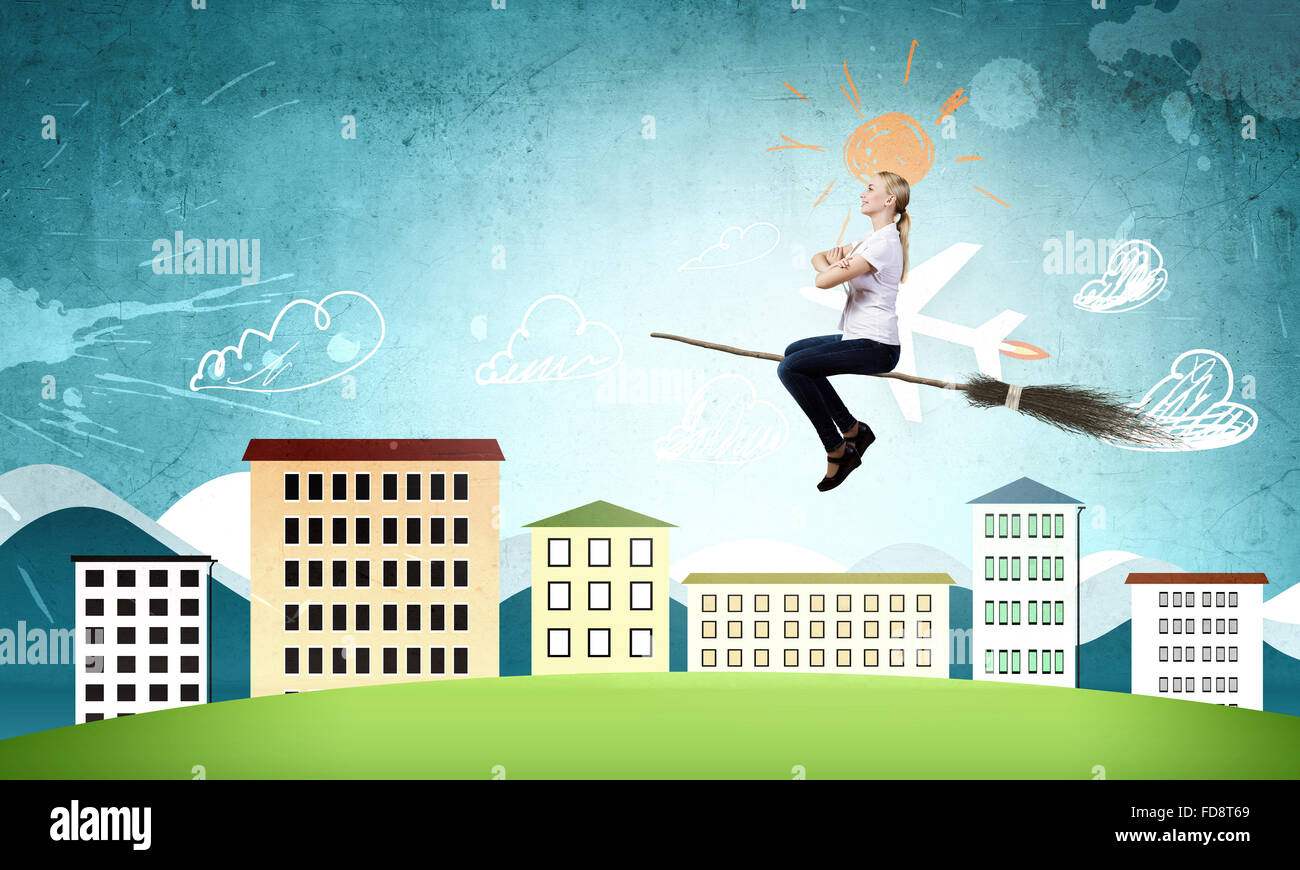 Young girl in casual flying on broom high in sky Stock Photo - Alamy