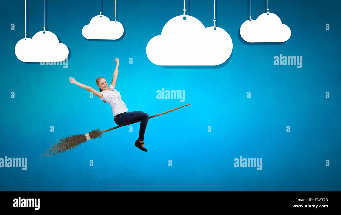 Young girl in casual flying on broom high in sky Stock Photo - Alamy