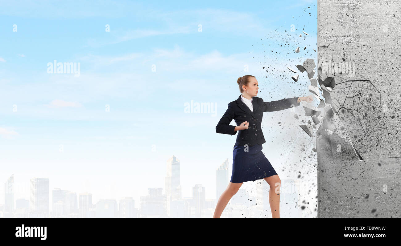 Businesswoman breaking stone wall with karate punch Stock Photo - Alamy