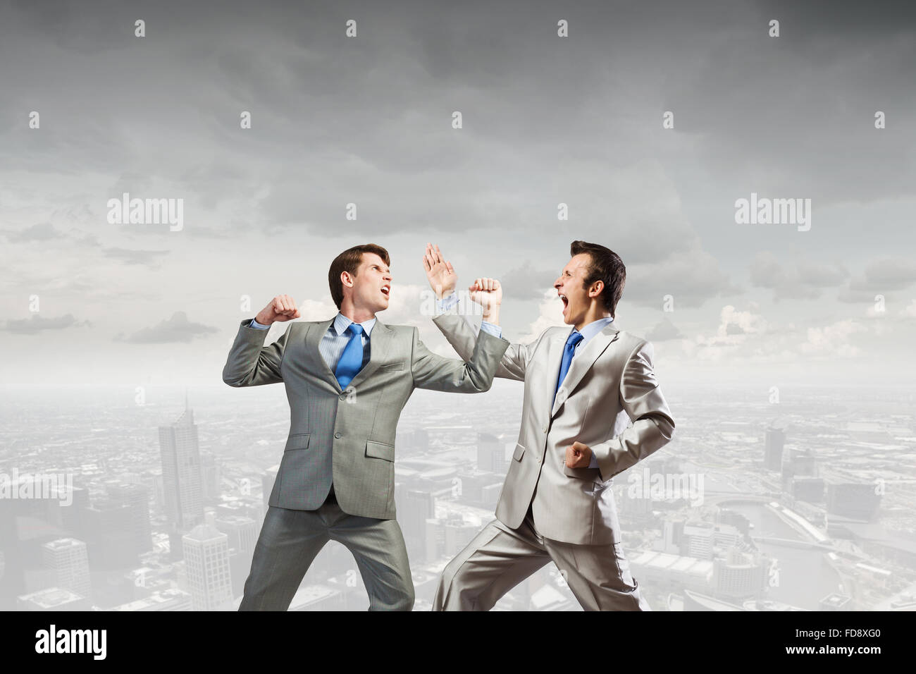 Two businesspeople in anger fighting with each other Stock Photo - Alamy