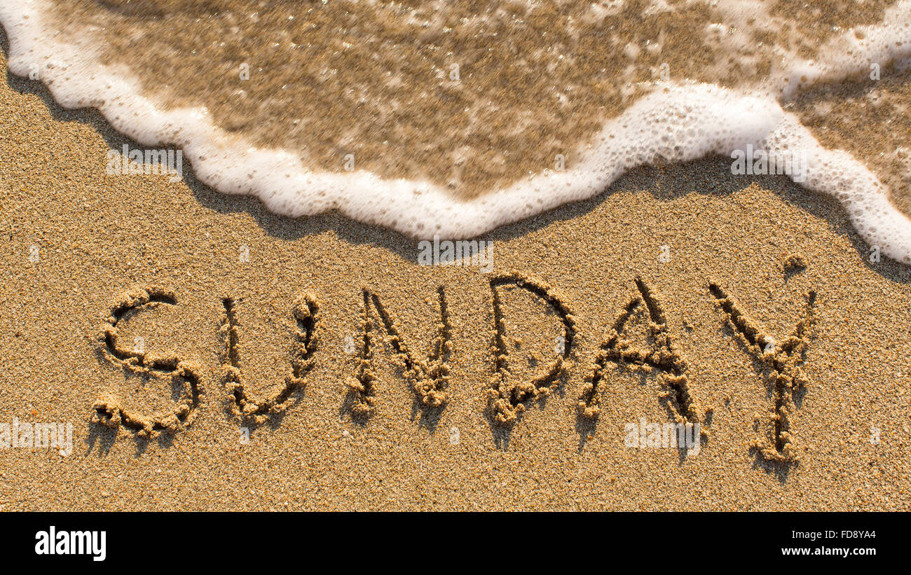 Inscription SUNDAY on a gentle beach sand with the soft wave.(days of ...