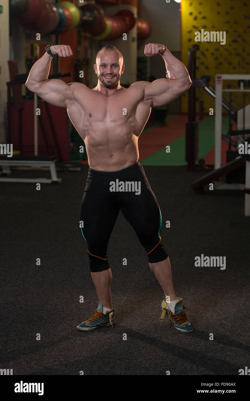 Serious Man Standing Strong In The Gym And Flexing Muscles Stock Photo ...