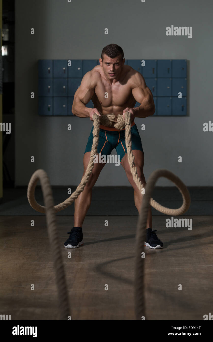 Battling Ropes Young Man At Gym Workout Exercise Stock Photo - Alamy