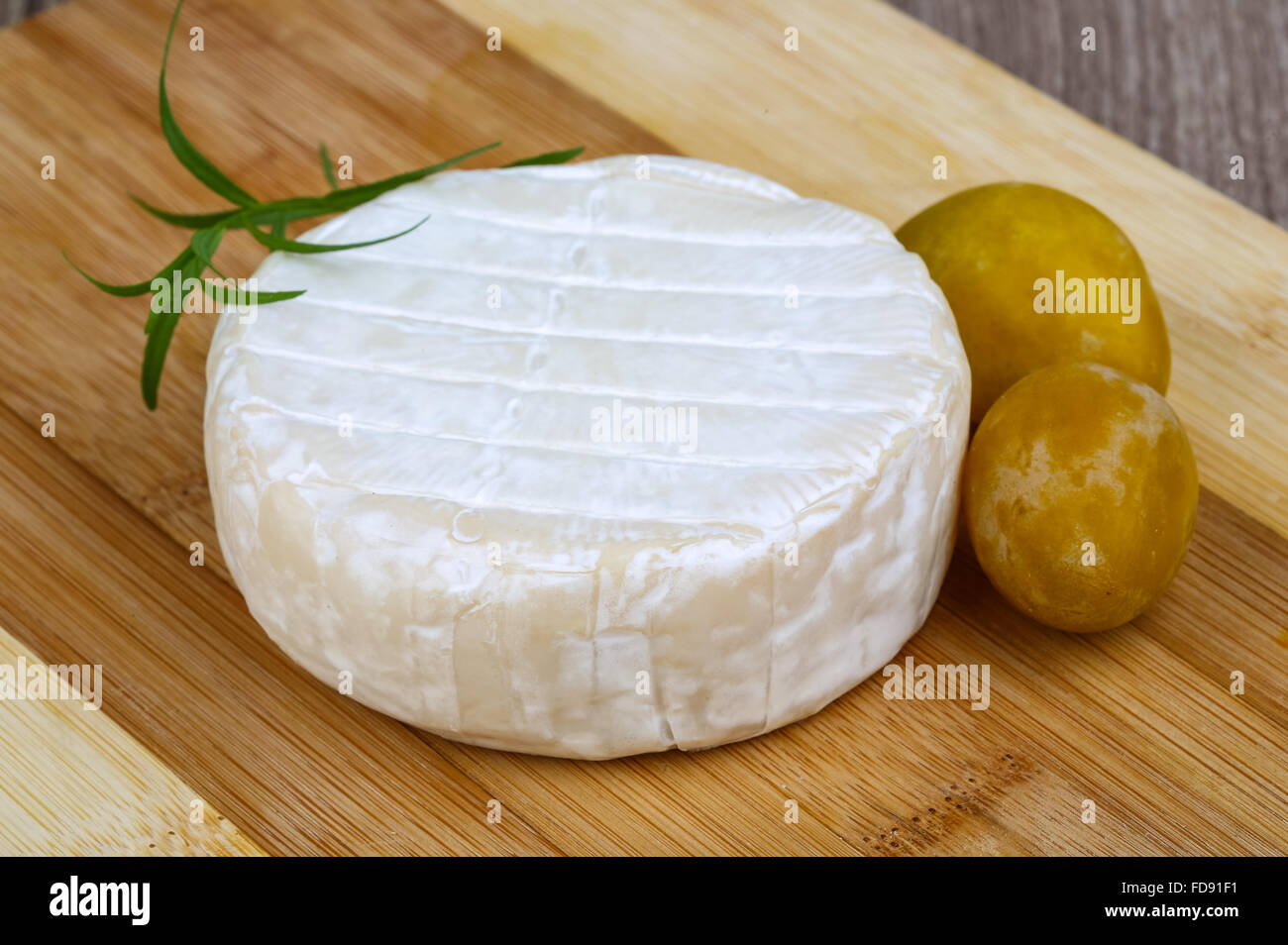 Round Brie cheese with yellow plums and estragon Stock Photo - Alamy