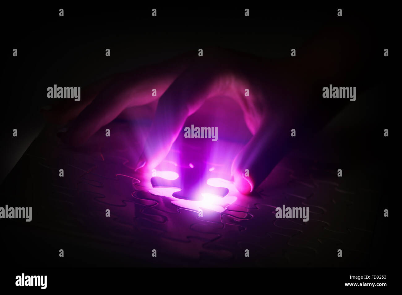 Close up of hands connecting puzzle element and making jigsaw complete ...