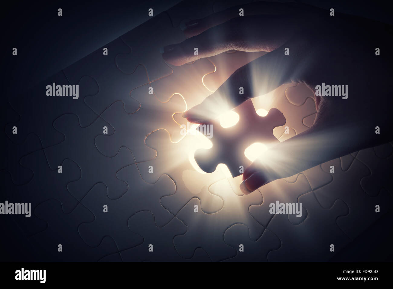 Close up of hands connecting puzzle element and making jigsaw complete ...