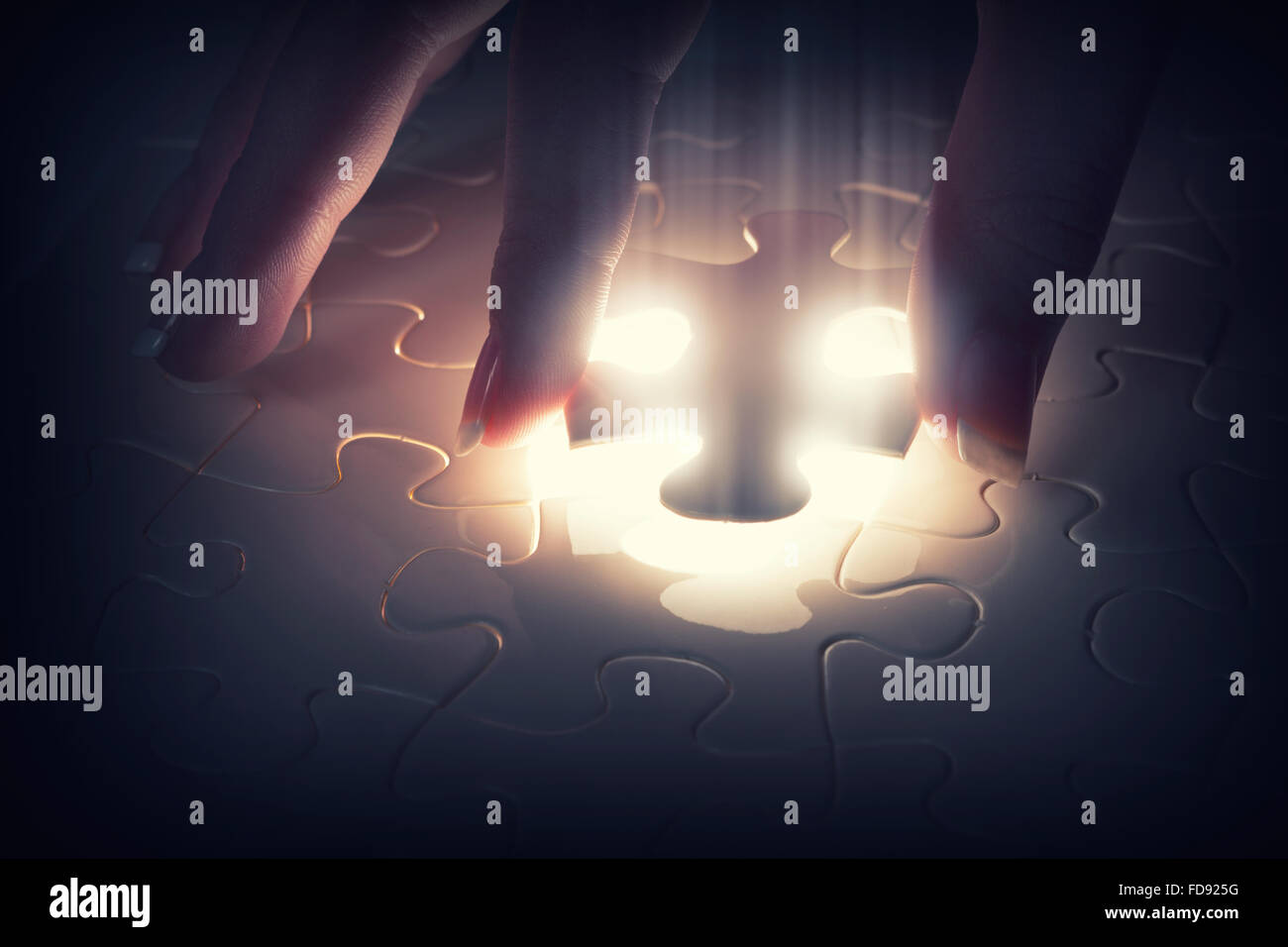 Close up of hands connecting puzzle element and making jigsaw complete ...