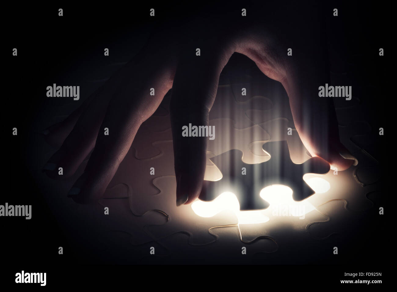 Close up of hands connecting puzzle element and making jigsaw complete ...