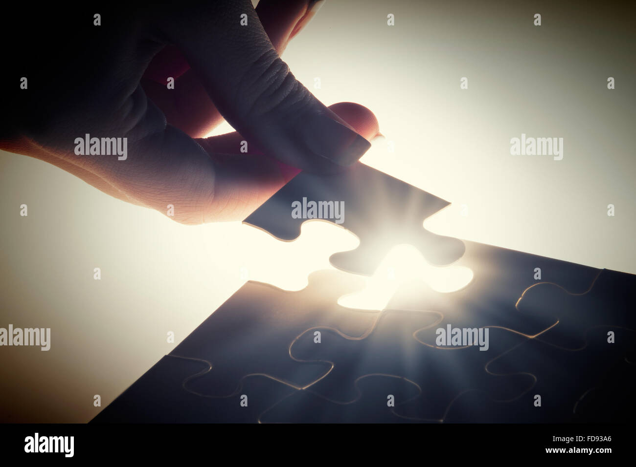 Close up of hands connecting puzzle element and making jigsaw complete ...