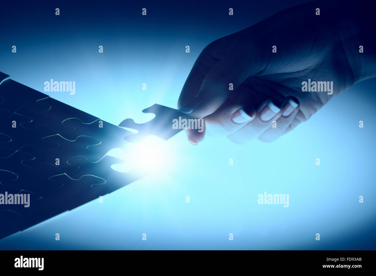 Close up of hands connecting puzzle element and making jigsaw complete ...