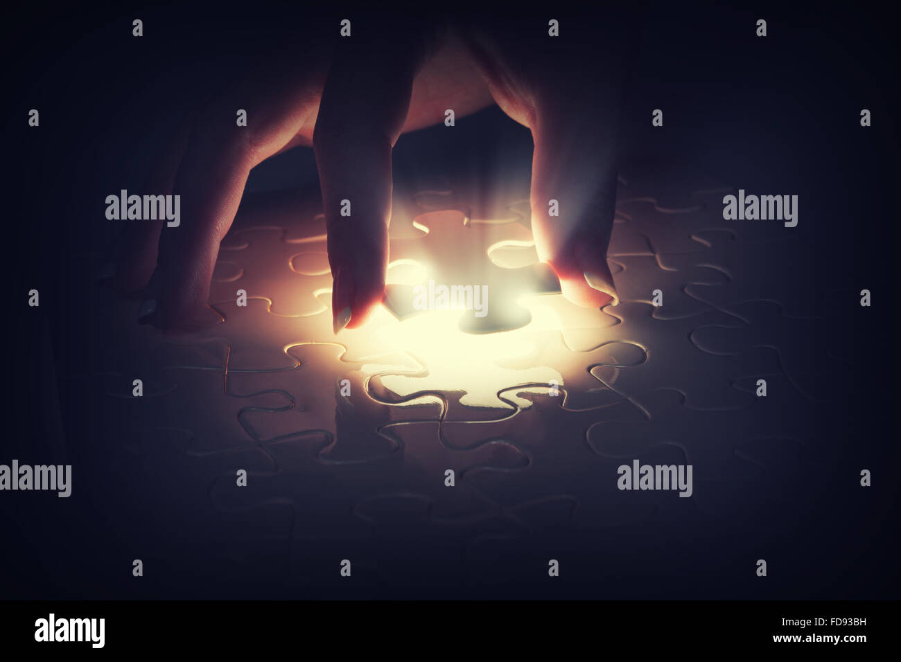 Close up of hands connecting puzzle element and making jigsaw complete ...