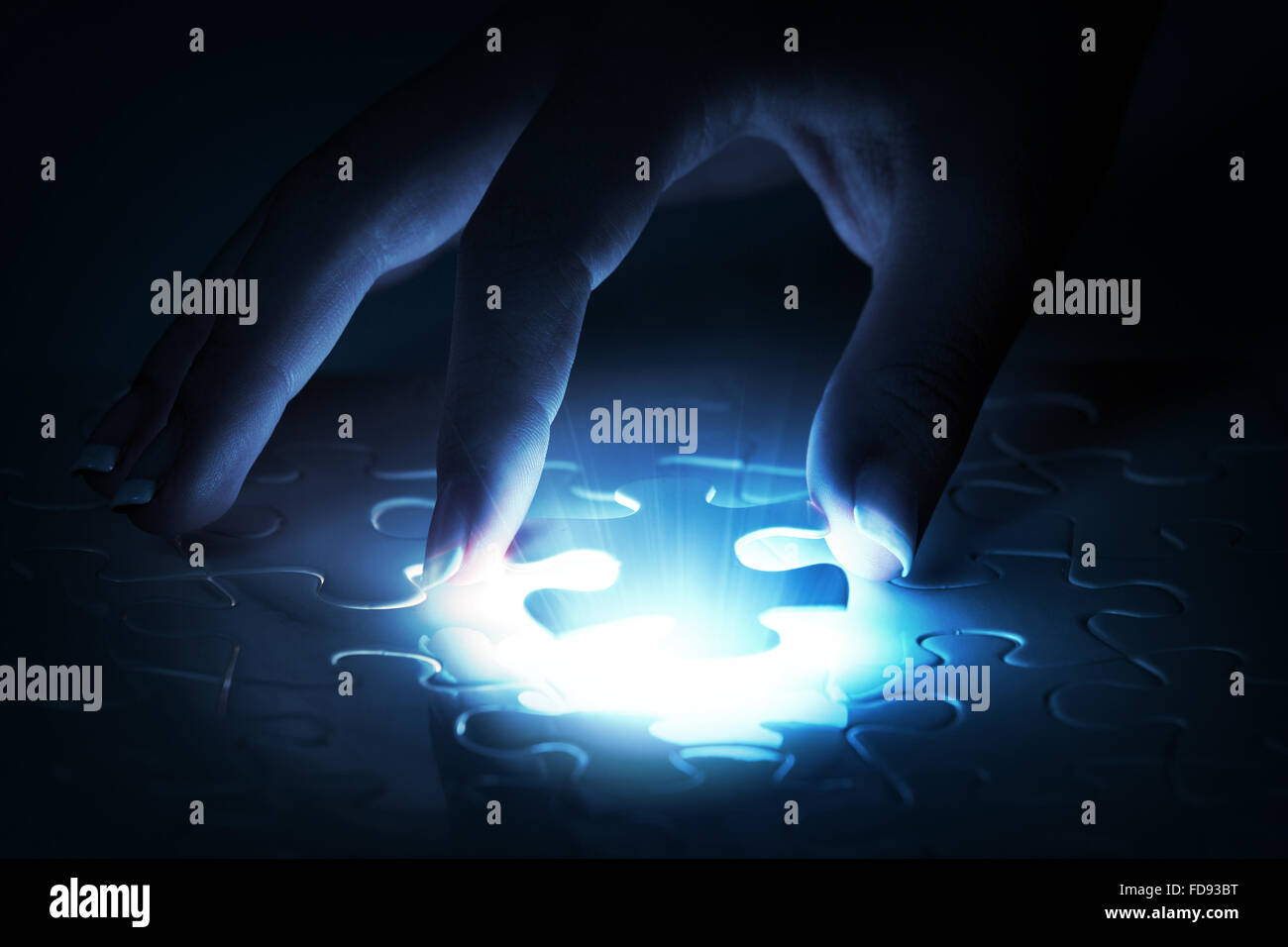Close up of hands connecting puzzle element and making jigsaw complete ...