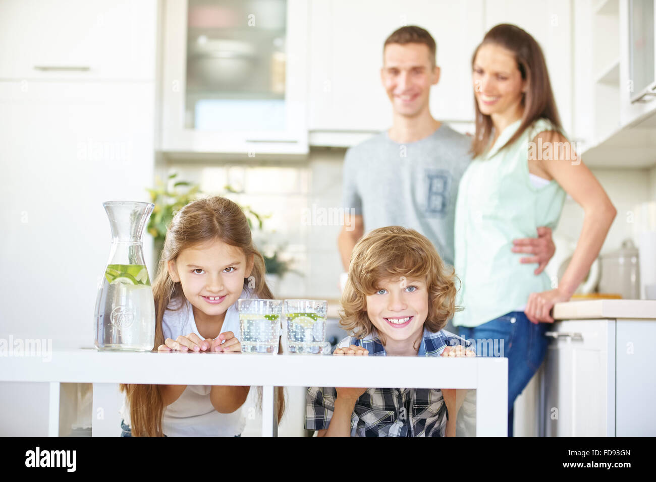 Happy family and two children in kitchen with fresh lime water Stock ...