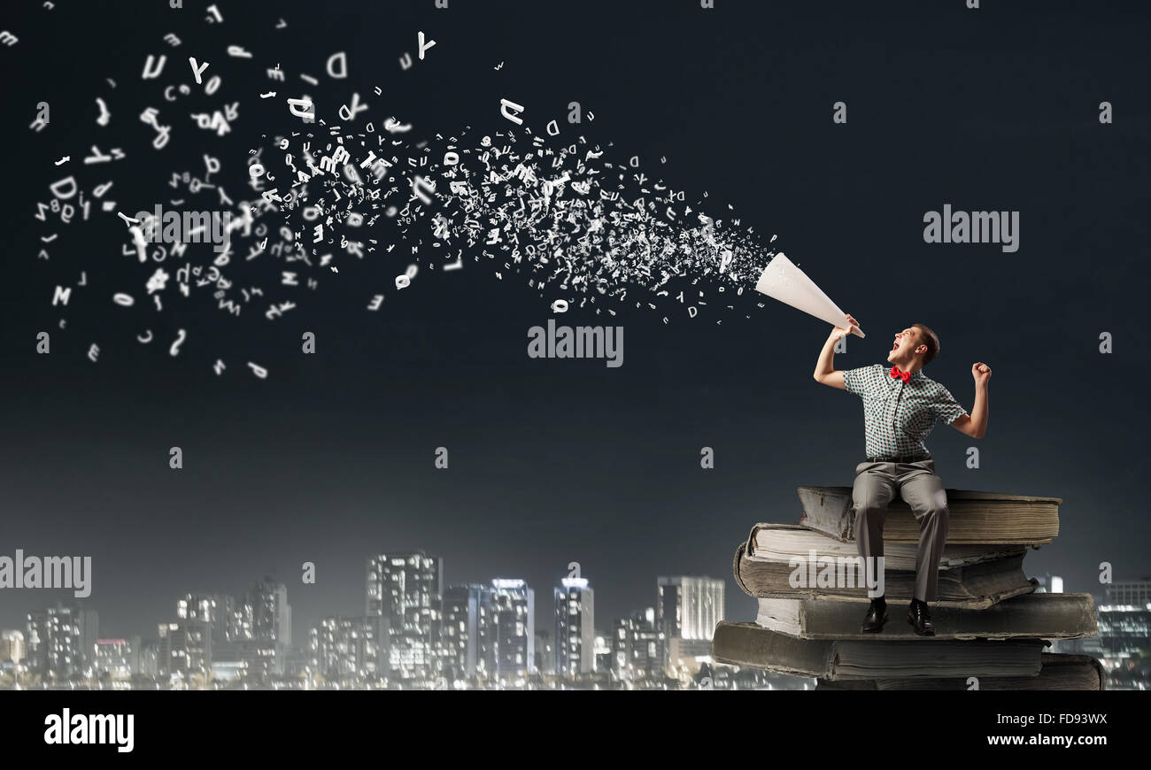 Young man in bow tie screaming in paper trumpet Stock Photo - Alamy