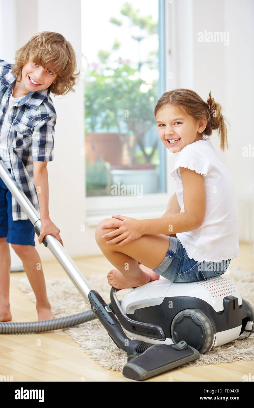 Two siblings cleaning at home with vacuum cleaner Stock Photo - Alamy