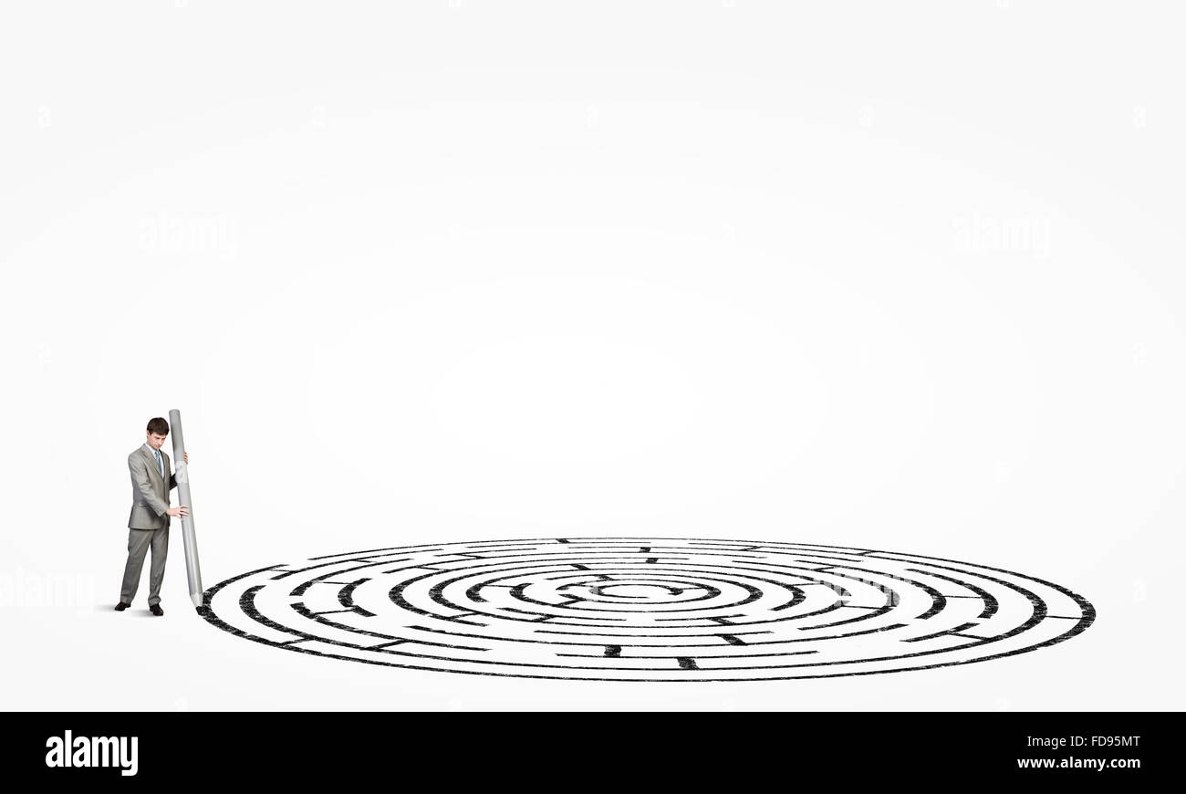 Young businessman drawing maze on floor with huge pencil Stock Photo ...
