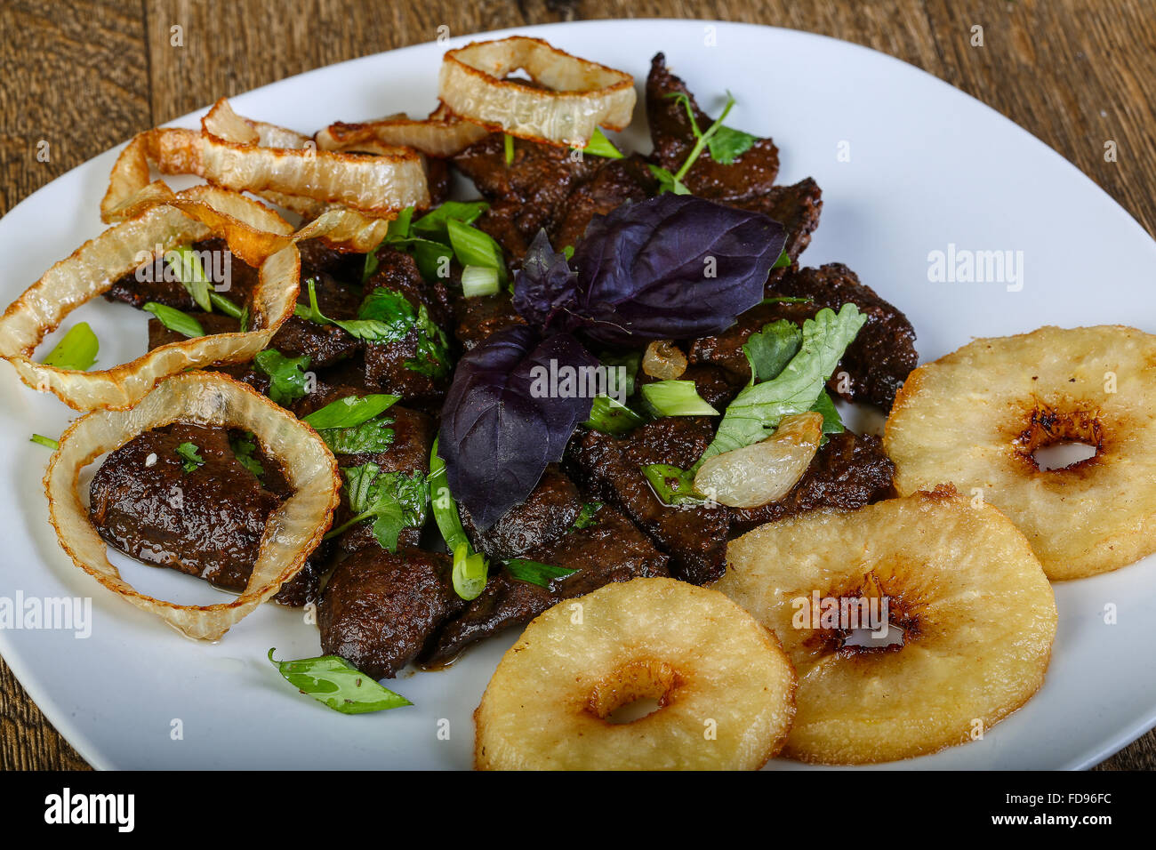 Grilled liver with onion rings and herbs Stock Photo - Alamy