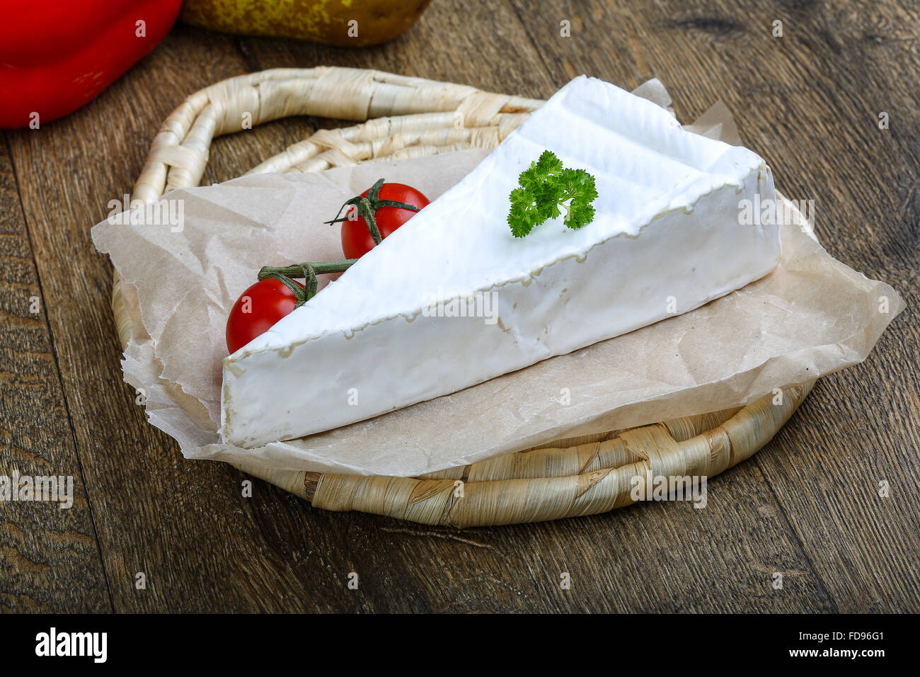 Brie cheese triangle with tomato and parsley Stock Photo - Alamy