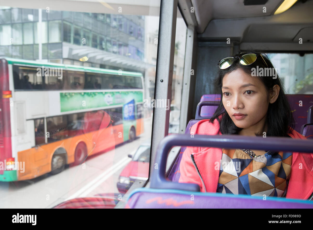 woman in a bus looking out the window at traffic in city Stock Photo ...