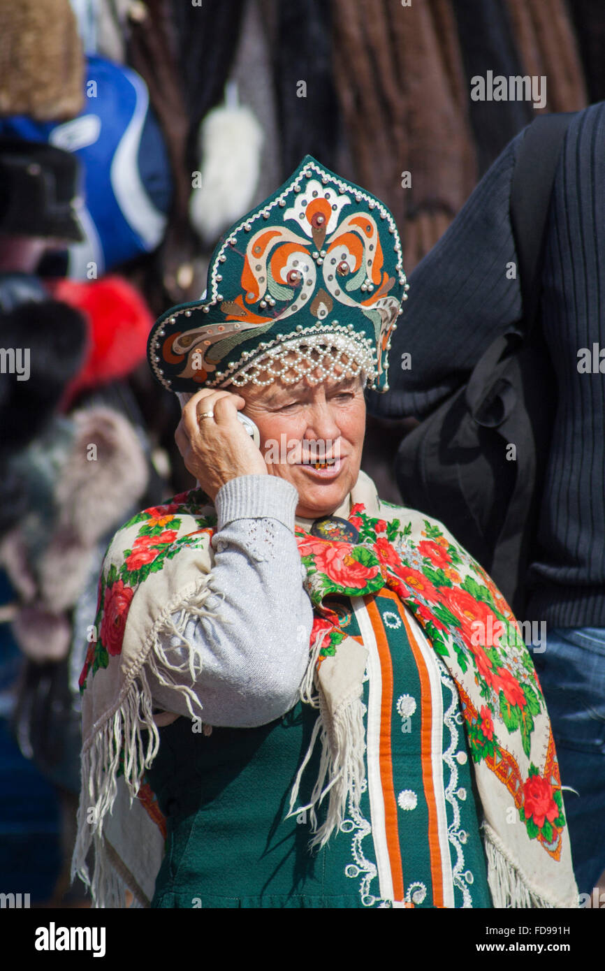 Russian singer in national dress talking on mobile phone at Izmailovsky ...
