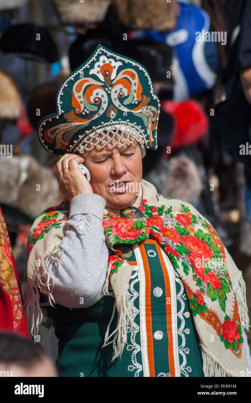 Russian singer in national dress talking on mobile phone at Izmailovsky ...