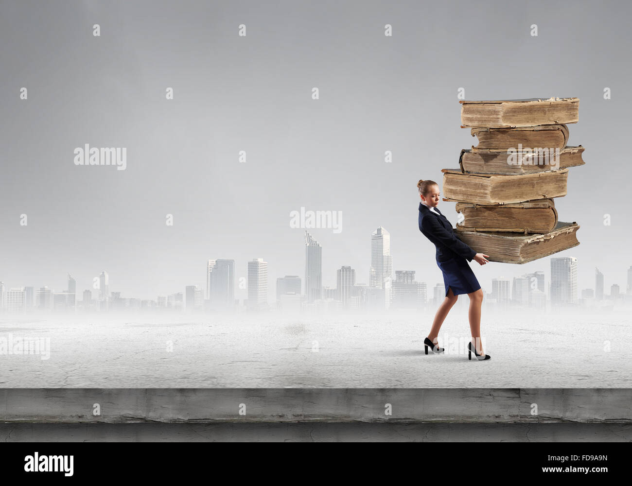 Young woman carrying huge pile of old books Stock Photo - Alamy