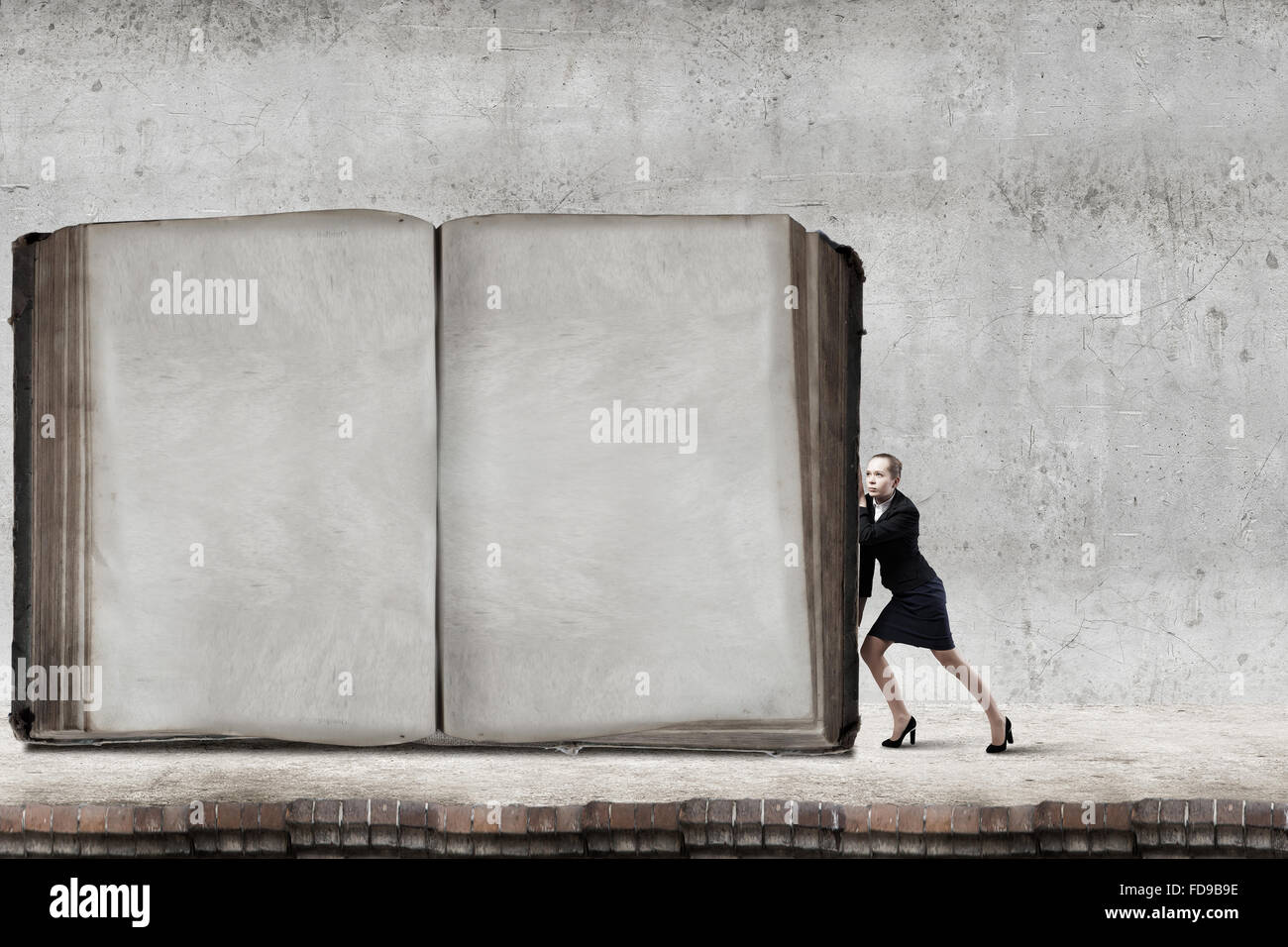 Young woman making effort to push huge old book Stock Photo - Alamy