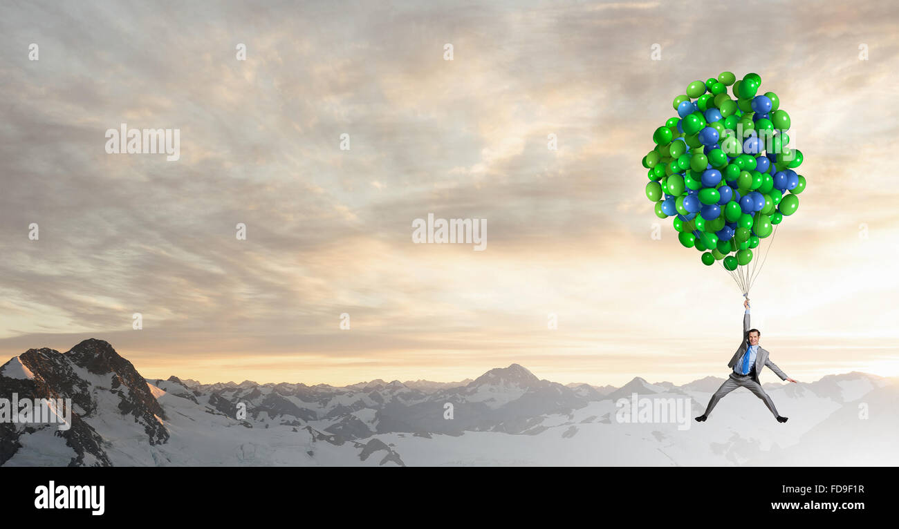 Young successful businessman flies on bunch of colorful balloons Stock ...