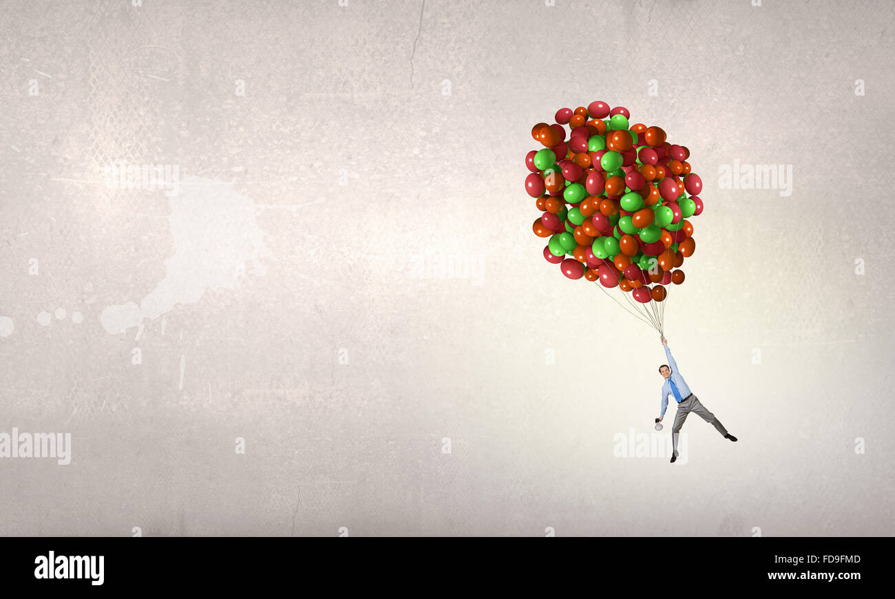 Young successful businessman flies on bunch of colorful balloons Stock ...