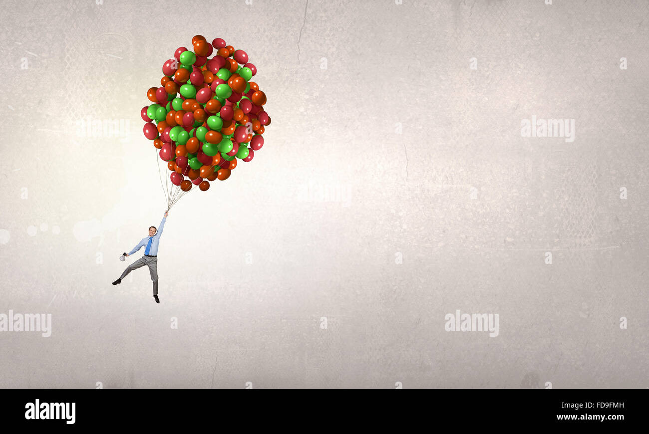 Young successful businessman flies on bunch of colorful balloons Stock ...