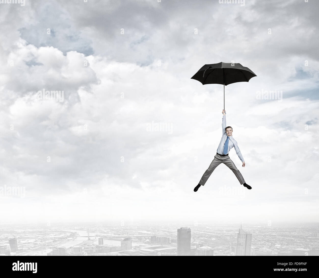 Young businessman flying high in sky on umbrella Stock Photo - Alamy
