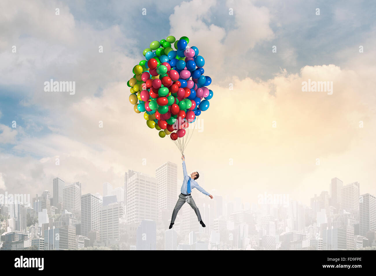Young successful businessman flies on bunch of colorful balloons Stock ...