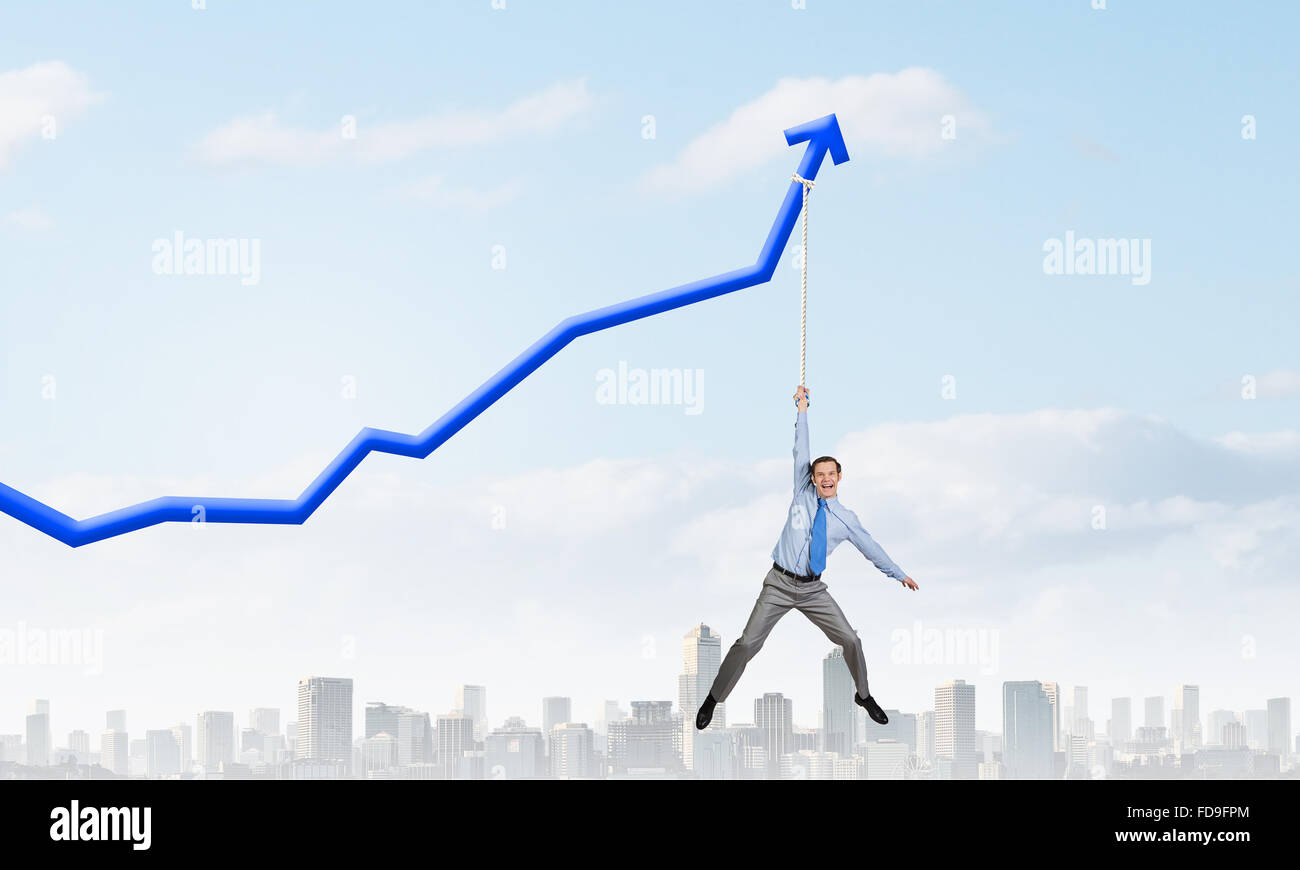 Young businessman hanging on increasing blue graph Stock Photo - Alamy