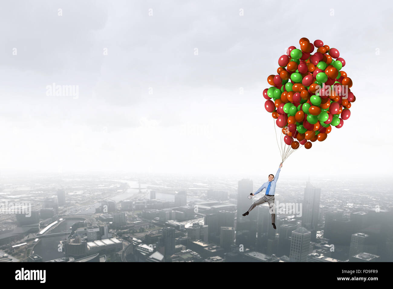 Young successful businessman flies on bunch of colorful balloons Stock ...