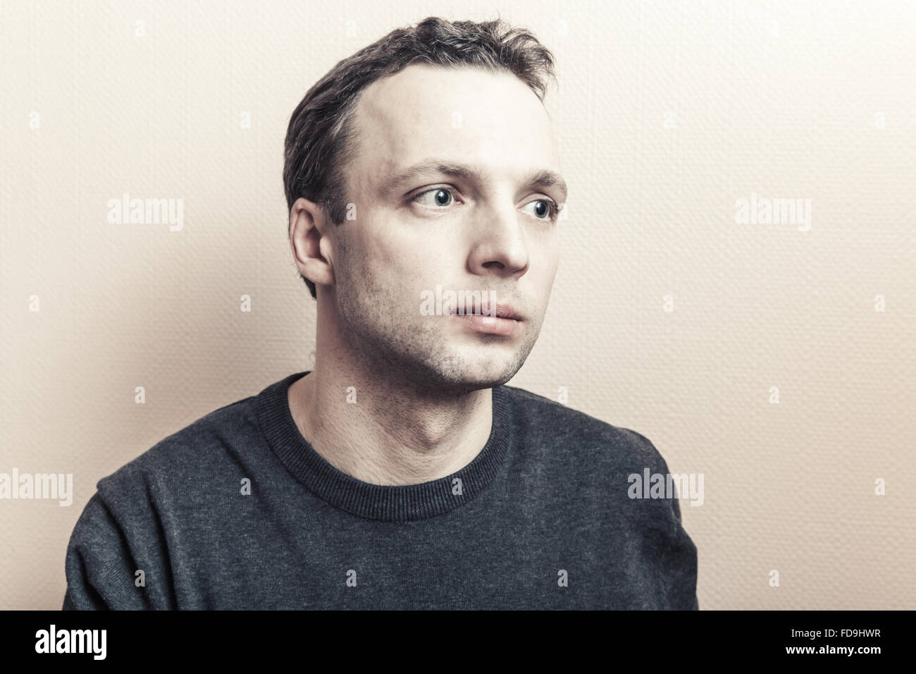 Young serious Caucasian man studio portrait over gray wall background ... Young serious Caucasian man studio portrait over gray wall background ...