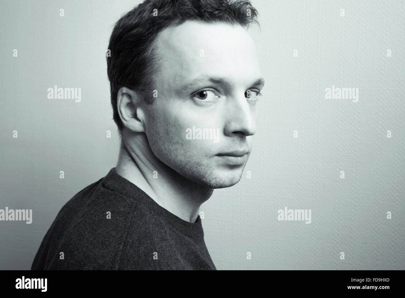 Young serious Caucasian man studio portrait over gray wall background ... Young serious Caucasian man studio portrait over gray wall background ...