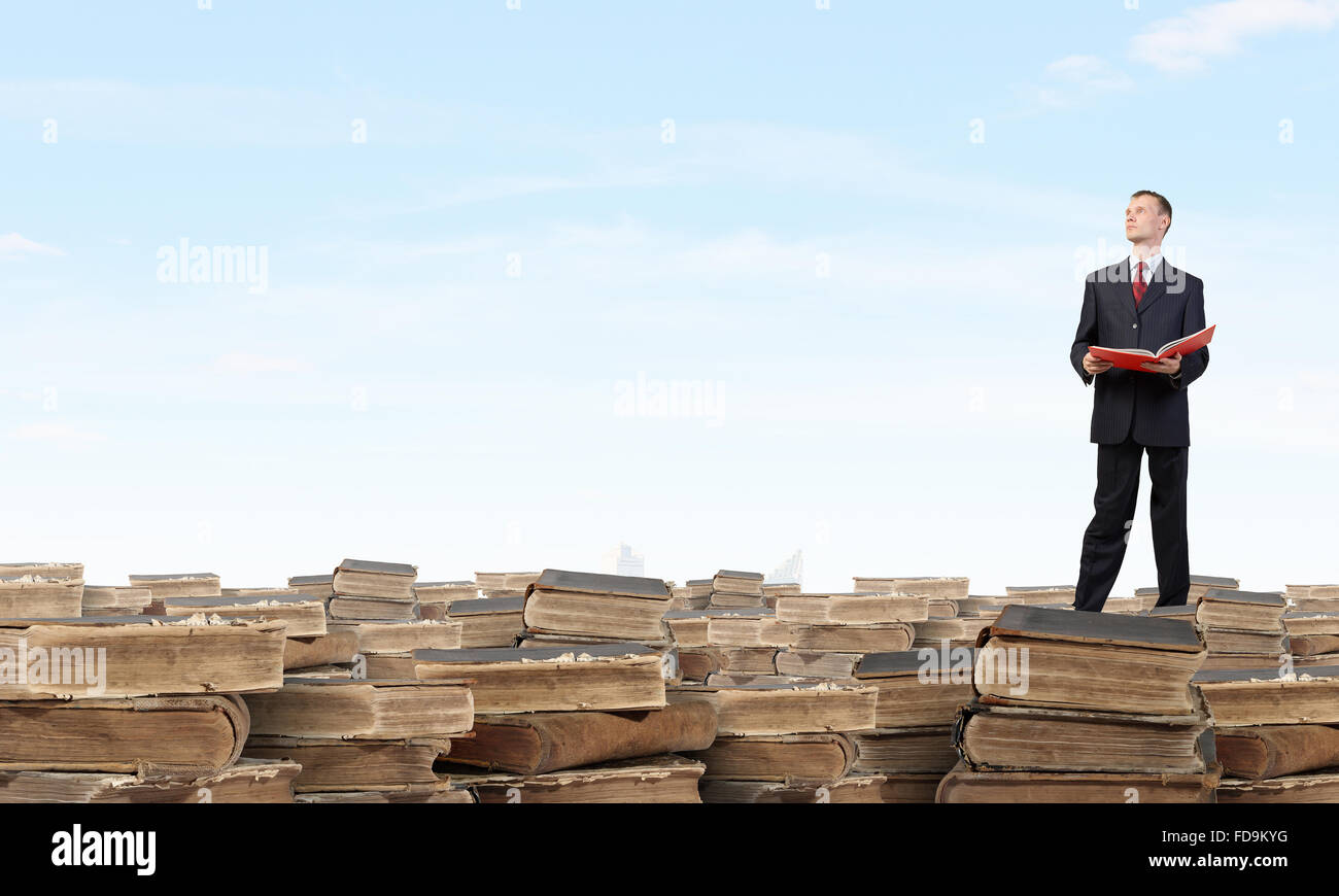 Standing man on book pile hi-res stock photography and images - Alamy
