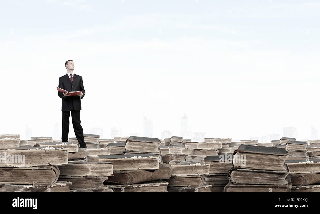 Standing man on book pile hi-res stock photography and images - Alamy