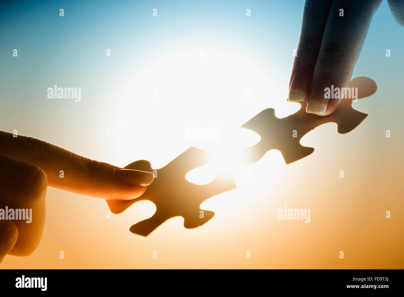 Hand connecting two jigsaw glowing puzzle pieces Stock Photo - Alamy