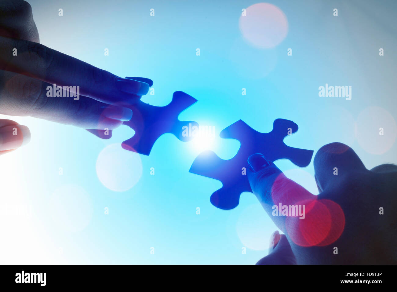 Hand connecting two jigsaw glowing puzzle pieces Stock Photo - Alamy