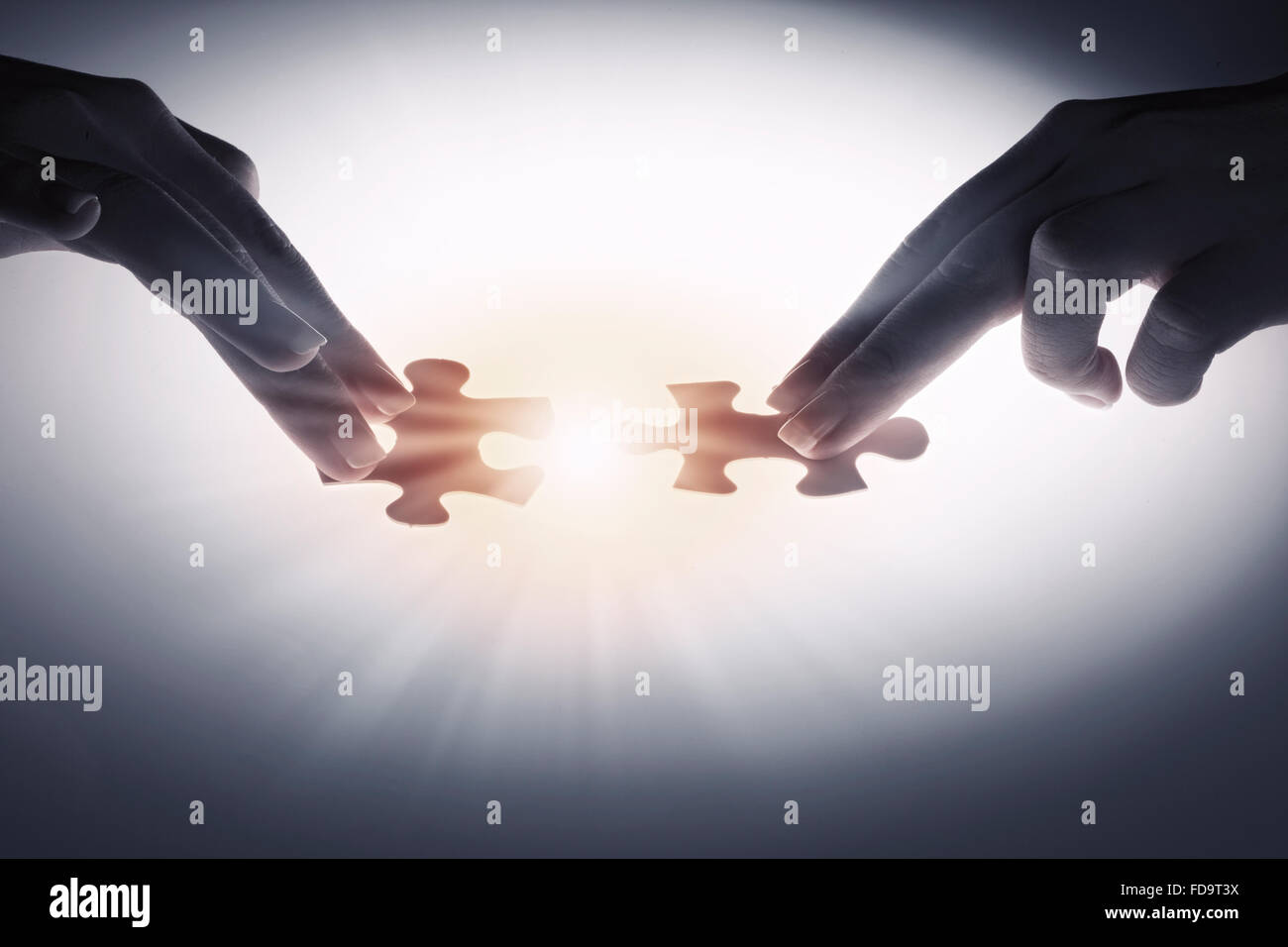 Hand connecting two jigsaw glowing puzzle pieces Stock Photo - Alamy
