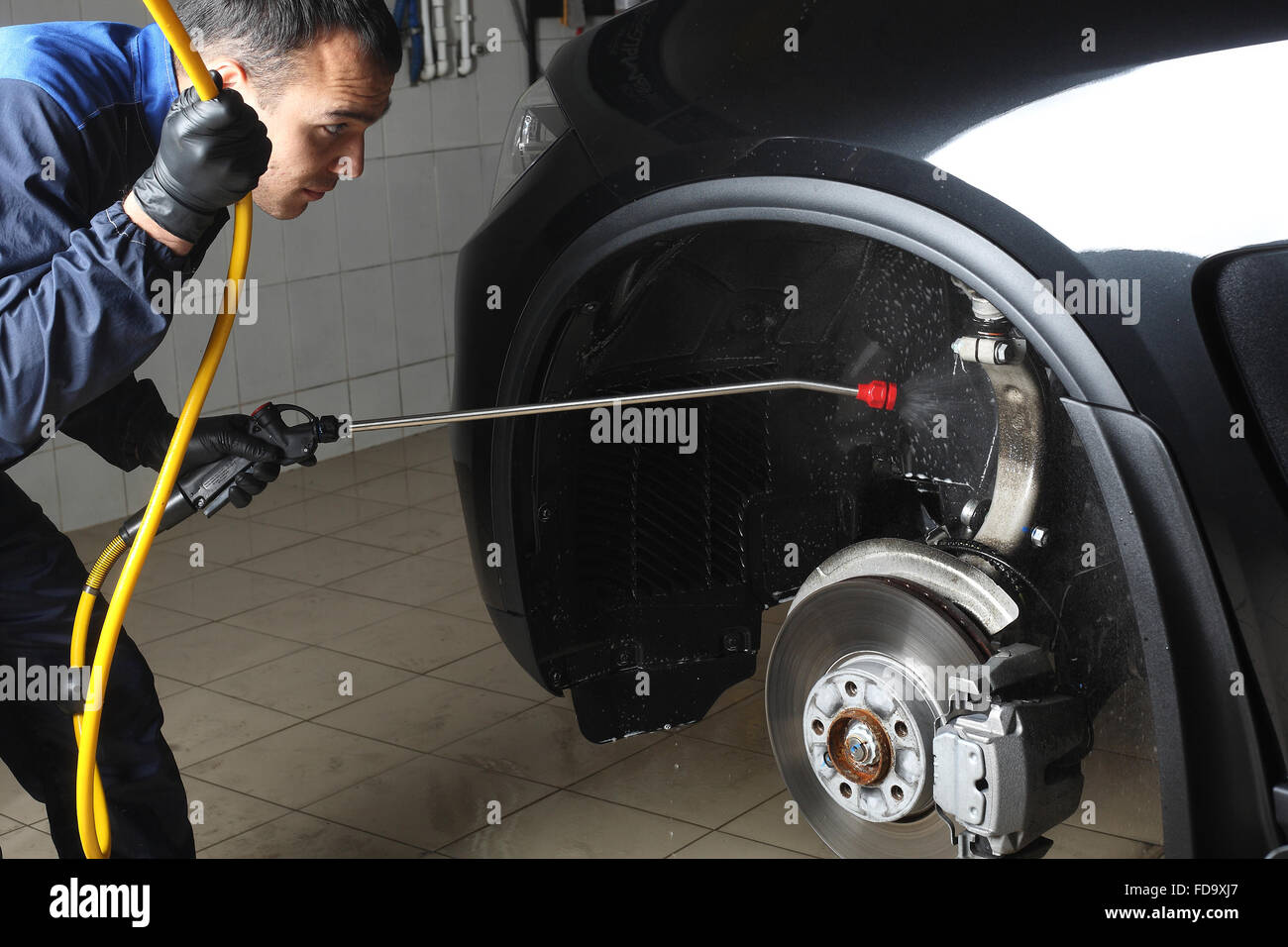 Illustrative editorial. The worker washing of the car under a high ...