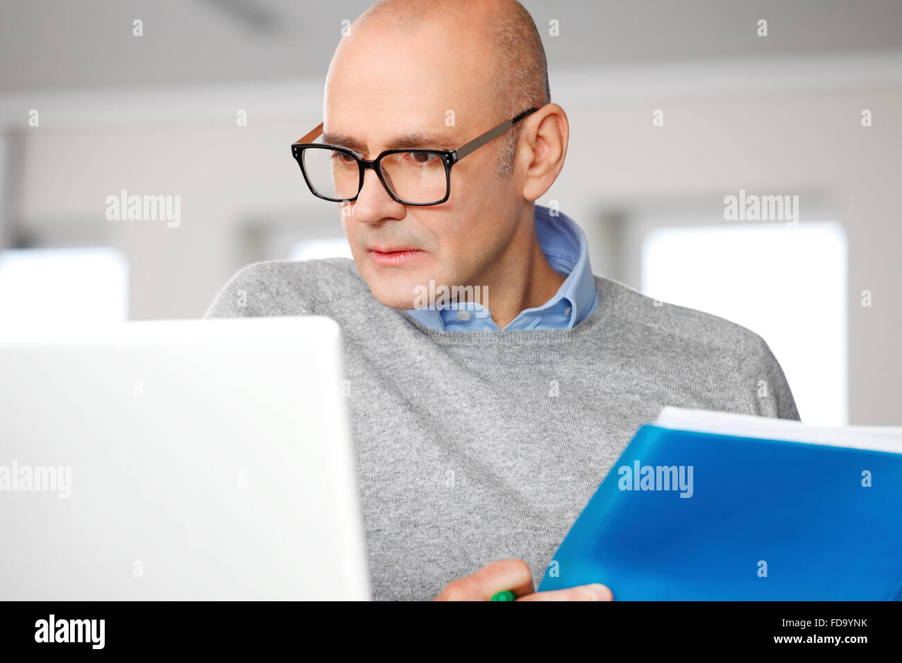 Portrait of senior chief financier officer sitting in front of computer ...