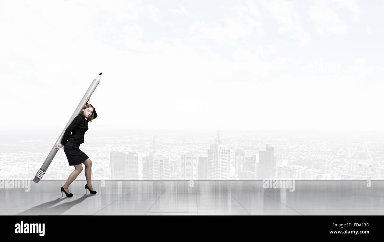 Young businesswoman carrying big pencil on back Stock Photo - Alamy