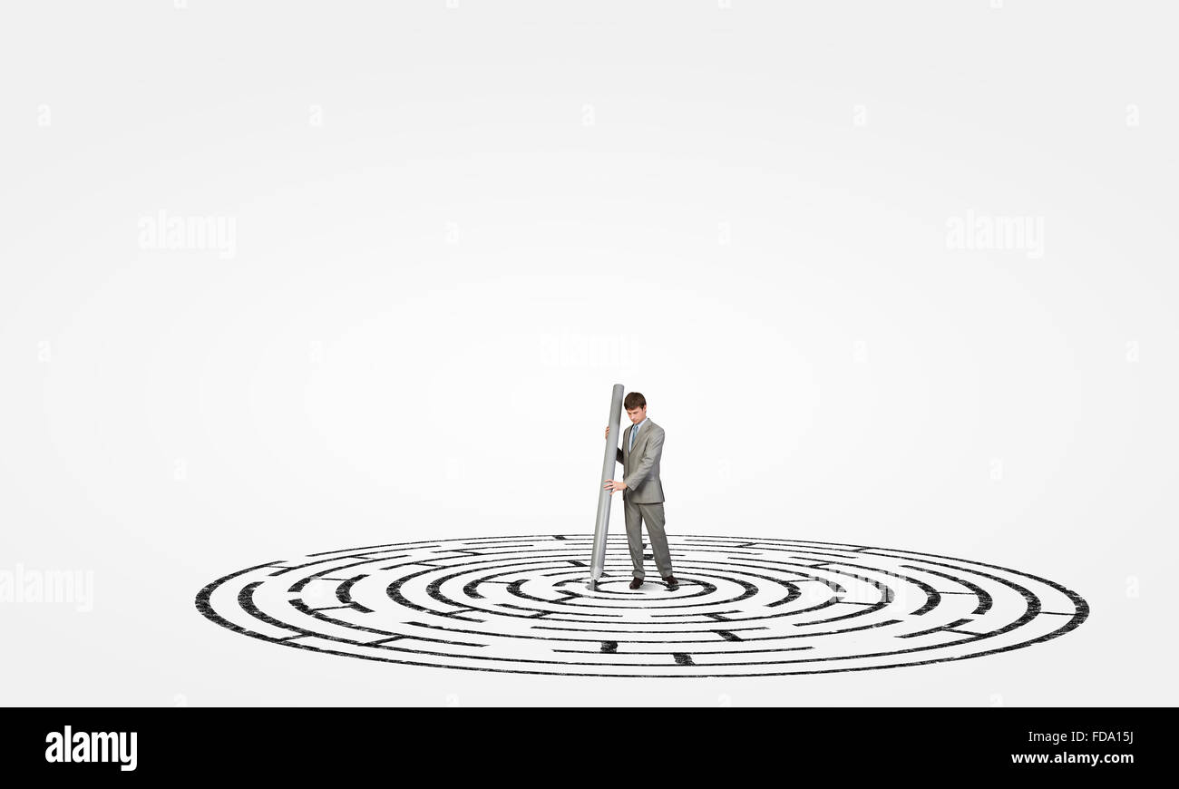 Young businessman drawing maze on floor with huge pencil Stock Photo ...