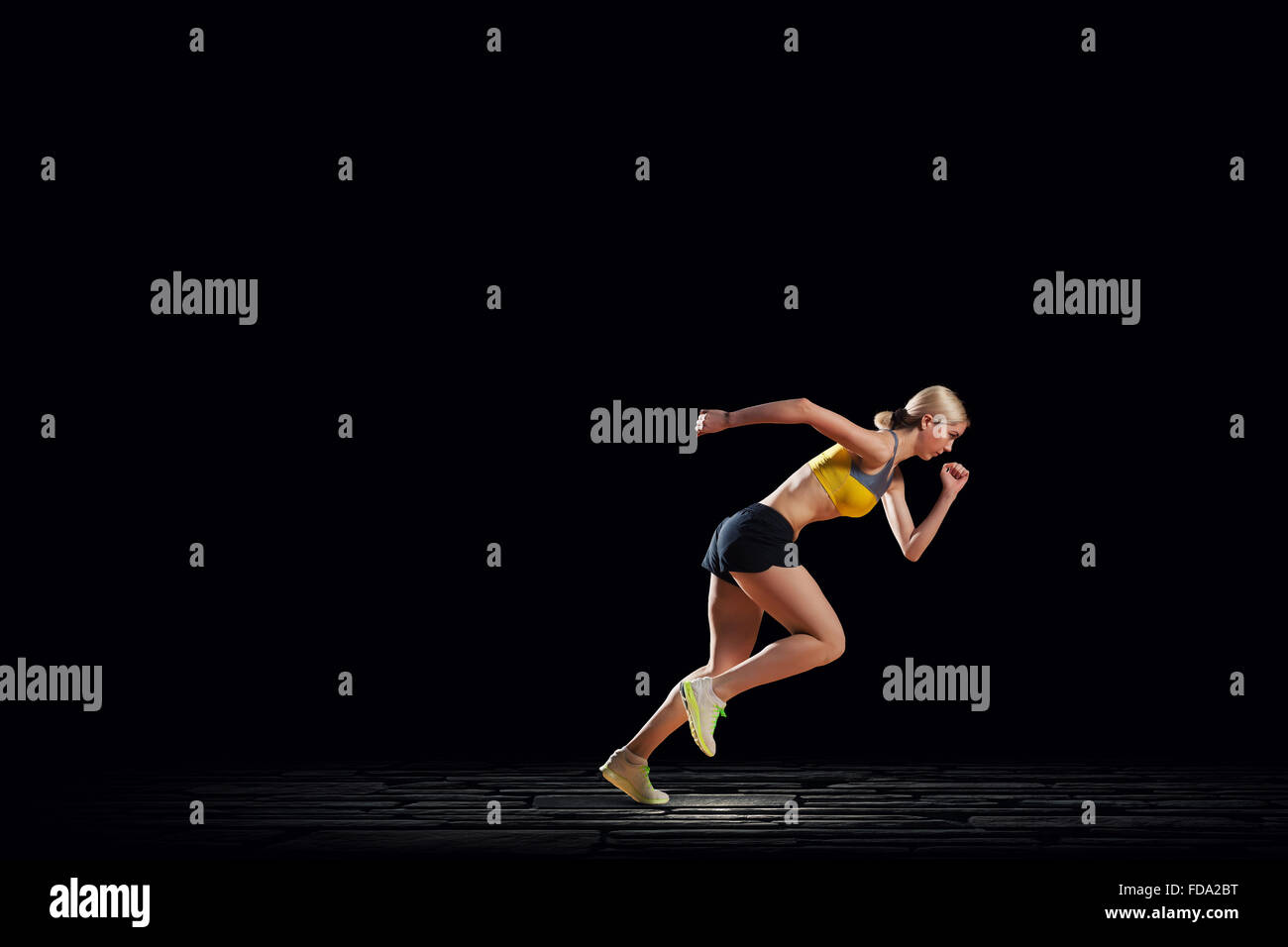 Young woman athlete running fast on dark background Stock Photo - Alamy