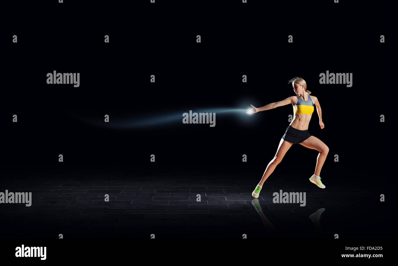 Young woman athlete running fast on dark background Stock Photo - Alamy