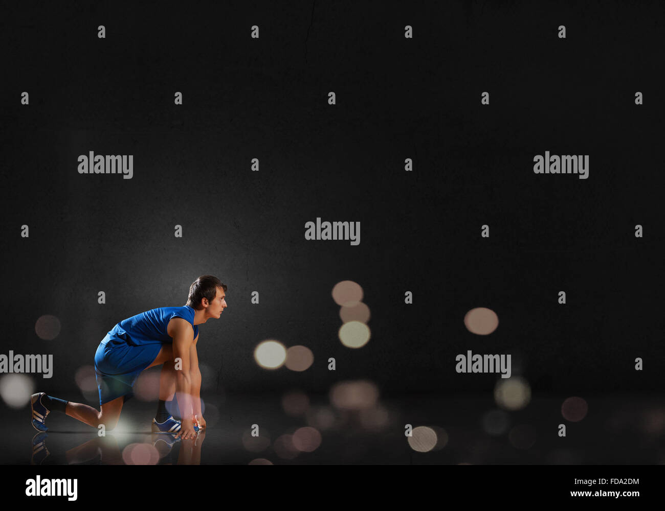 Young man athlete standing in start pose Stock Photo - Alamy